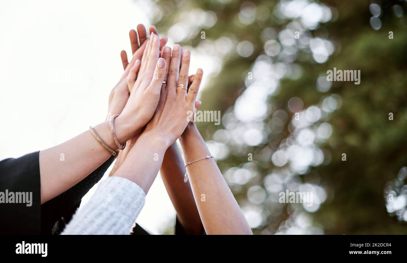 We did it. Closeup shot of a group of students giving each other a high ...