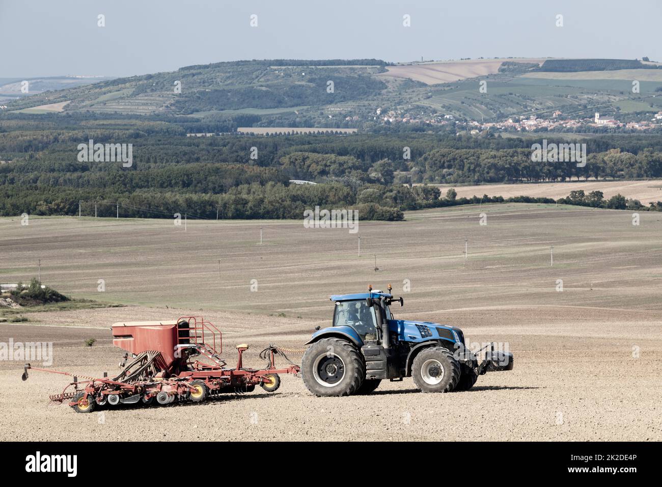 Tractor with seed drill in early spring landscape Stock Photo - Alamy