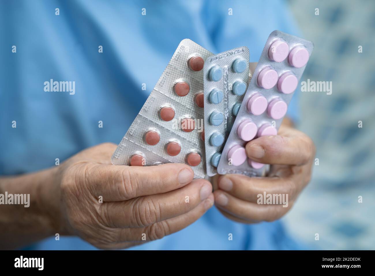 Asian senior elderly old lady woman holding pills drug in her hand ...