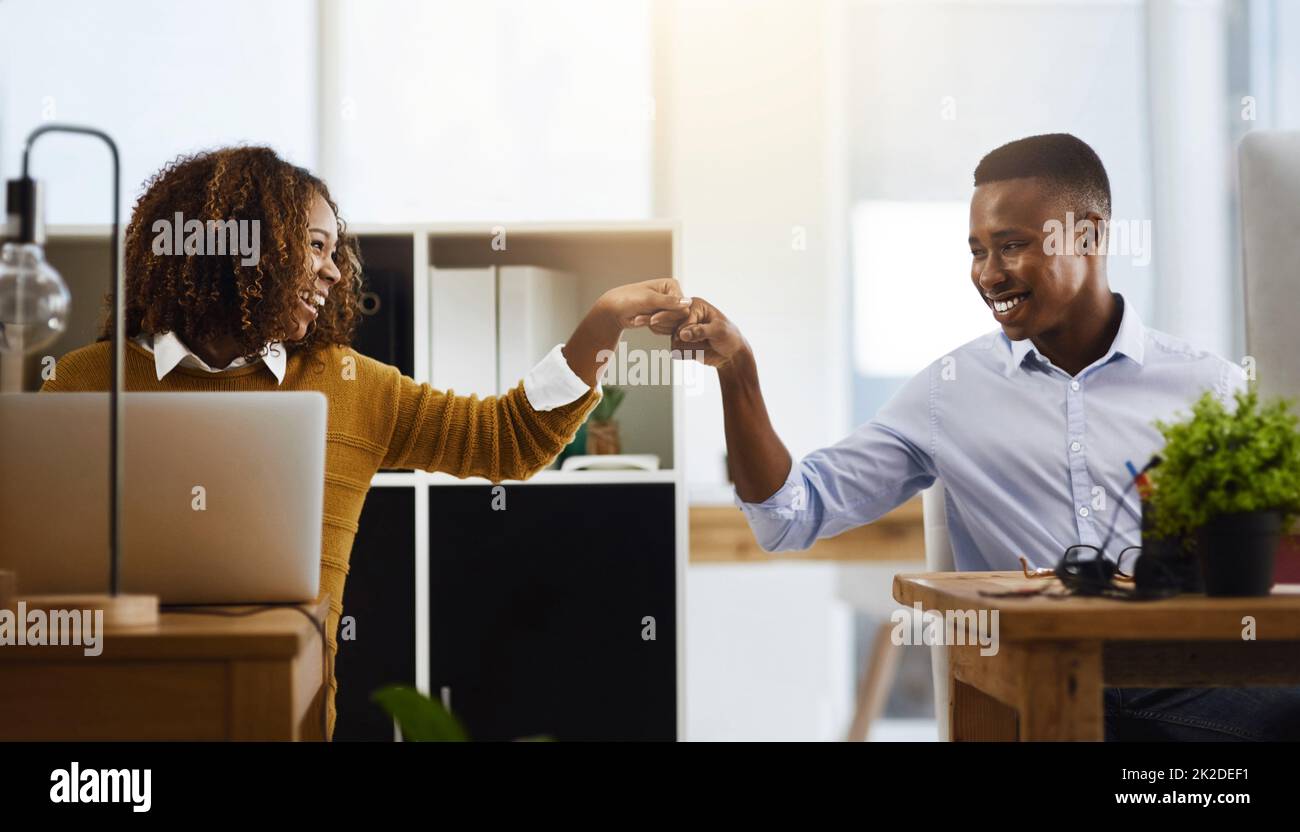 Bring it in partner. Shot of two young work colleagues greeting each ...