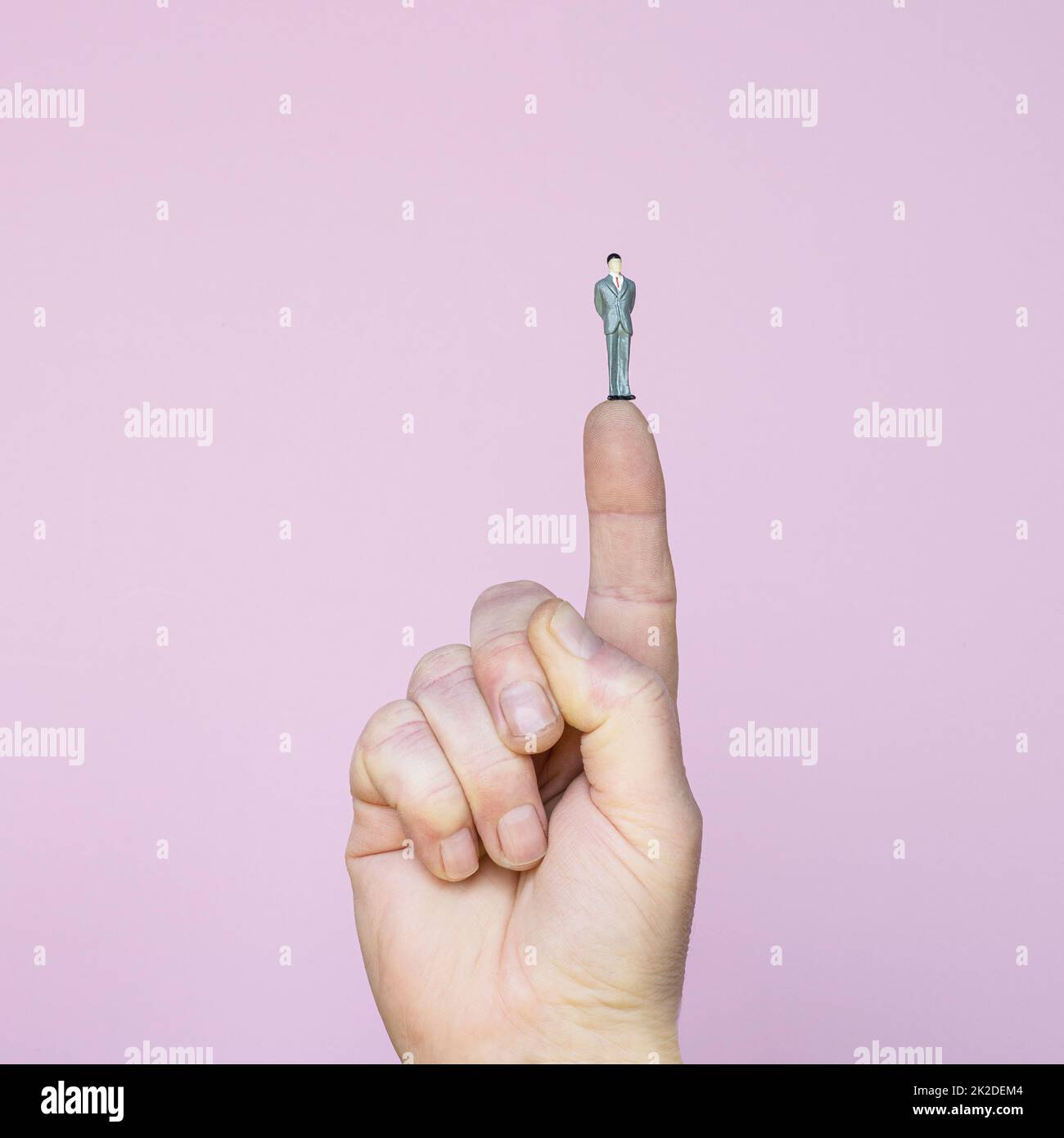 the figurine of a man on the tip of a finger Stock Photo - Alamy