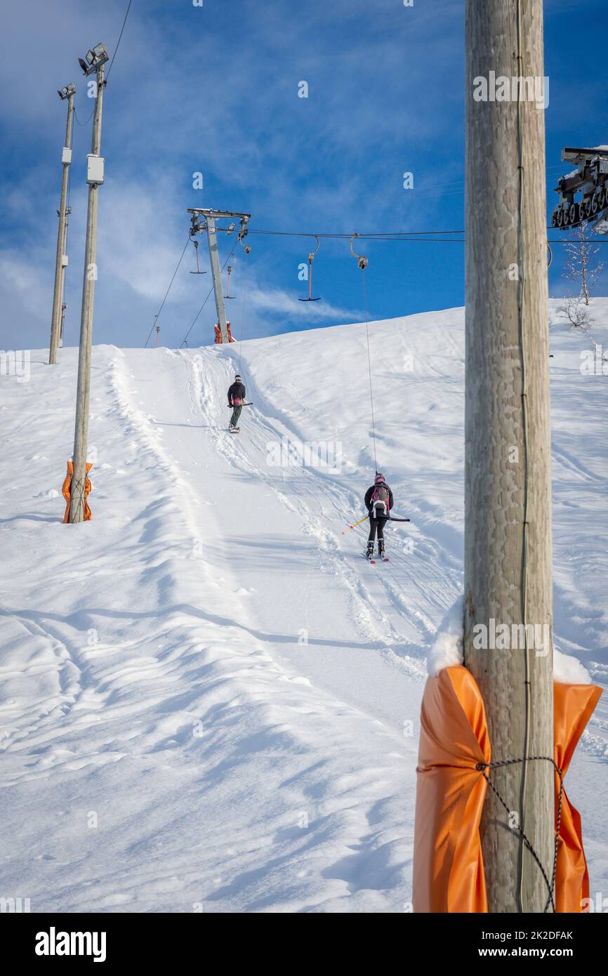 Woman with ski and man with snowboard using ski lift Stock Photo - Alamy