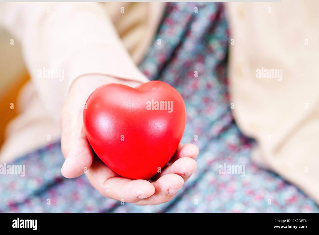 Asian elder senior woman patient holding red heart in hospital Stock ...