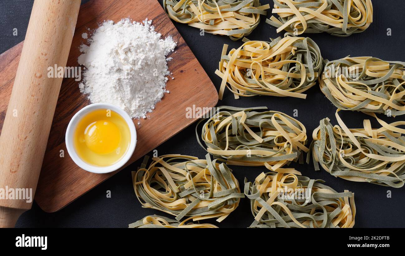 Uncooked Italian homemade egg pasta with spinach placed side by side ...