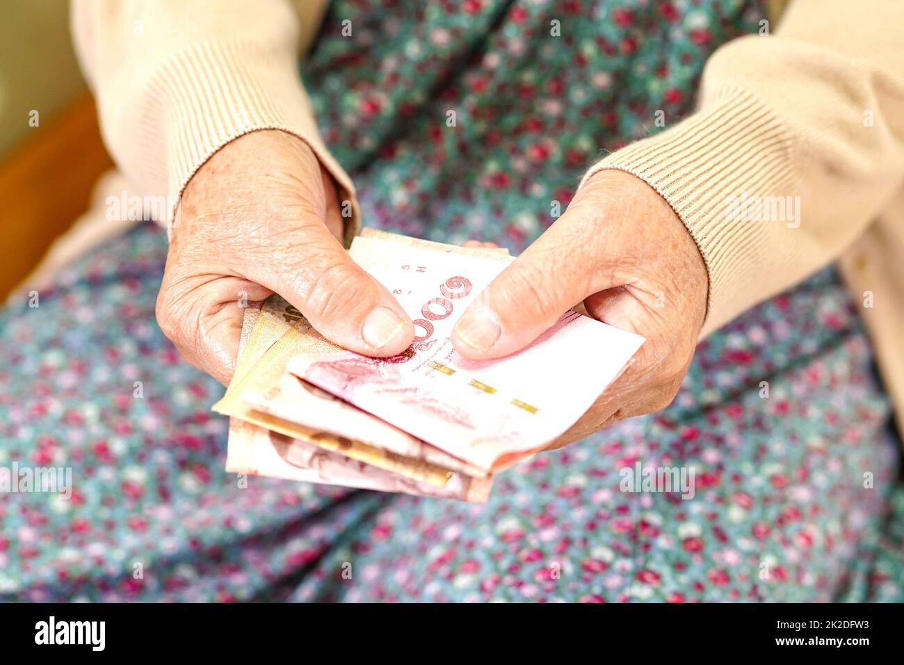Asian elder senior woman patient holding banknotes money in her hand ...