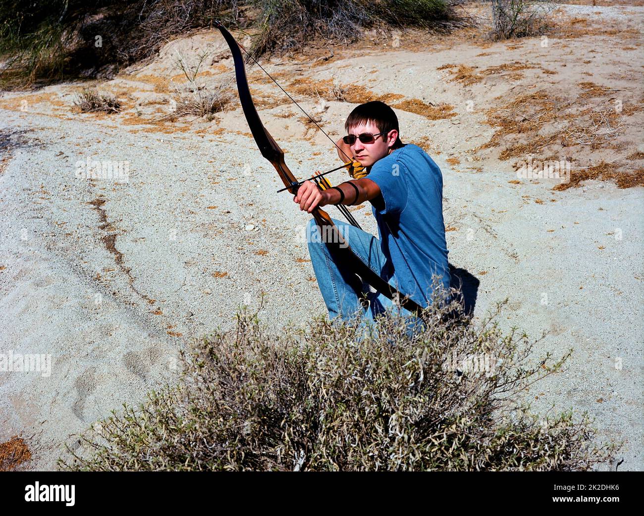 Young boy shooting a bow and arrow Stock Photo - Alamy