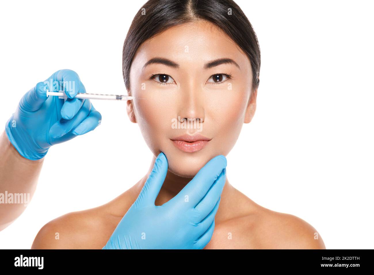 Asian woman during cheekbone modulation or filler injection procedure ...
