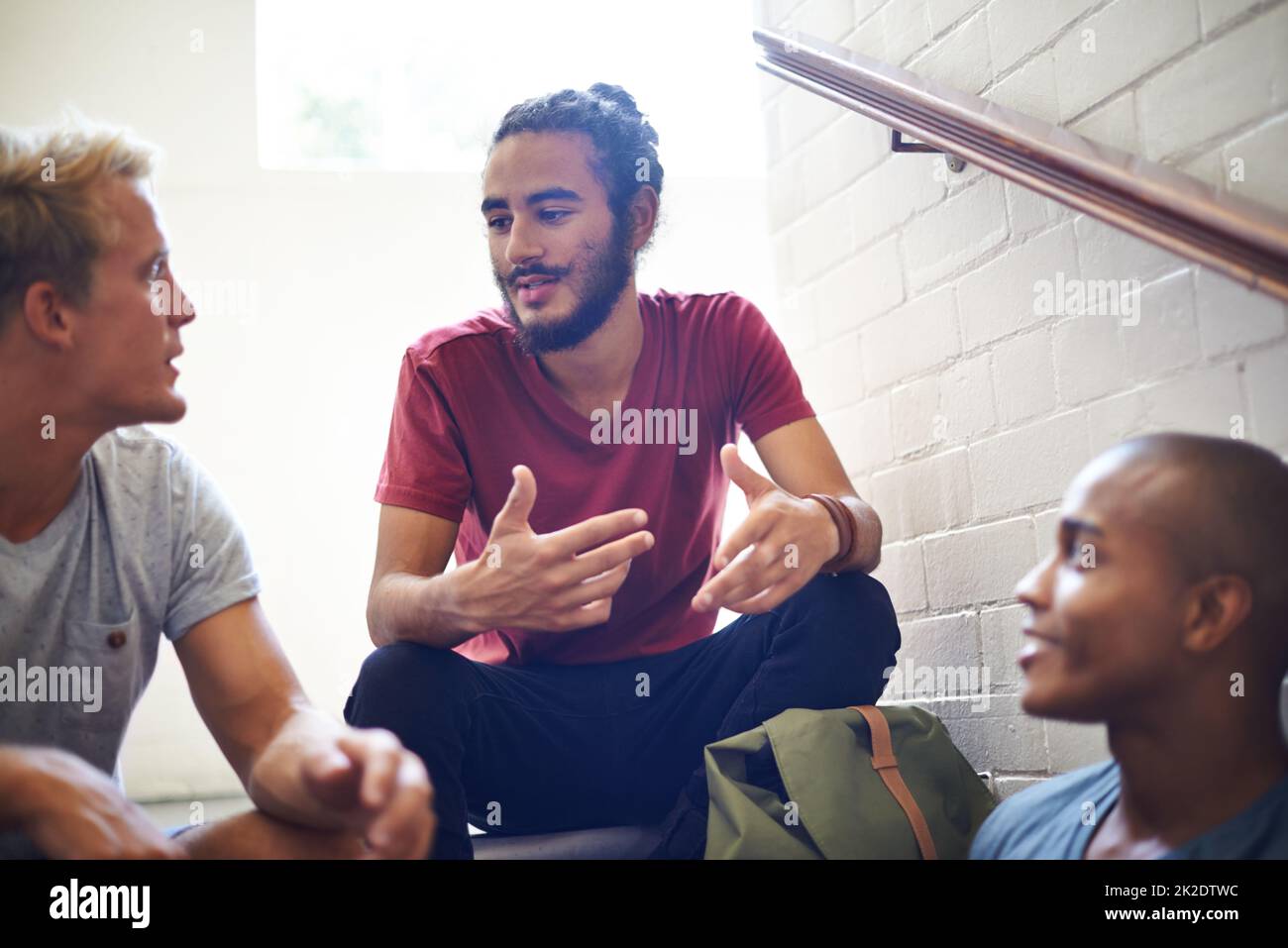 Serious talk between bros. Shot of male university students sitting and ...