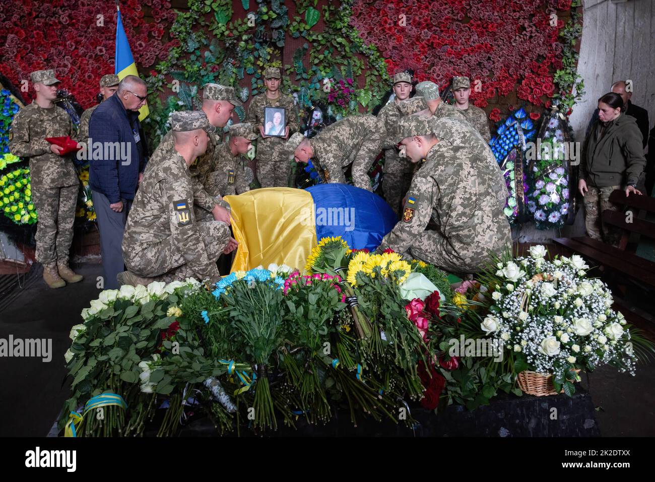 Members of the Honour Guard raise the flag over the coffin during a ...