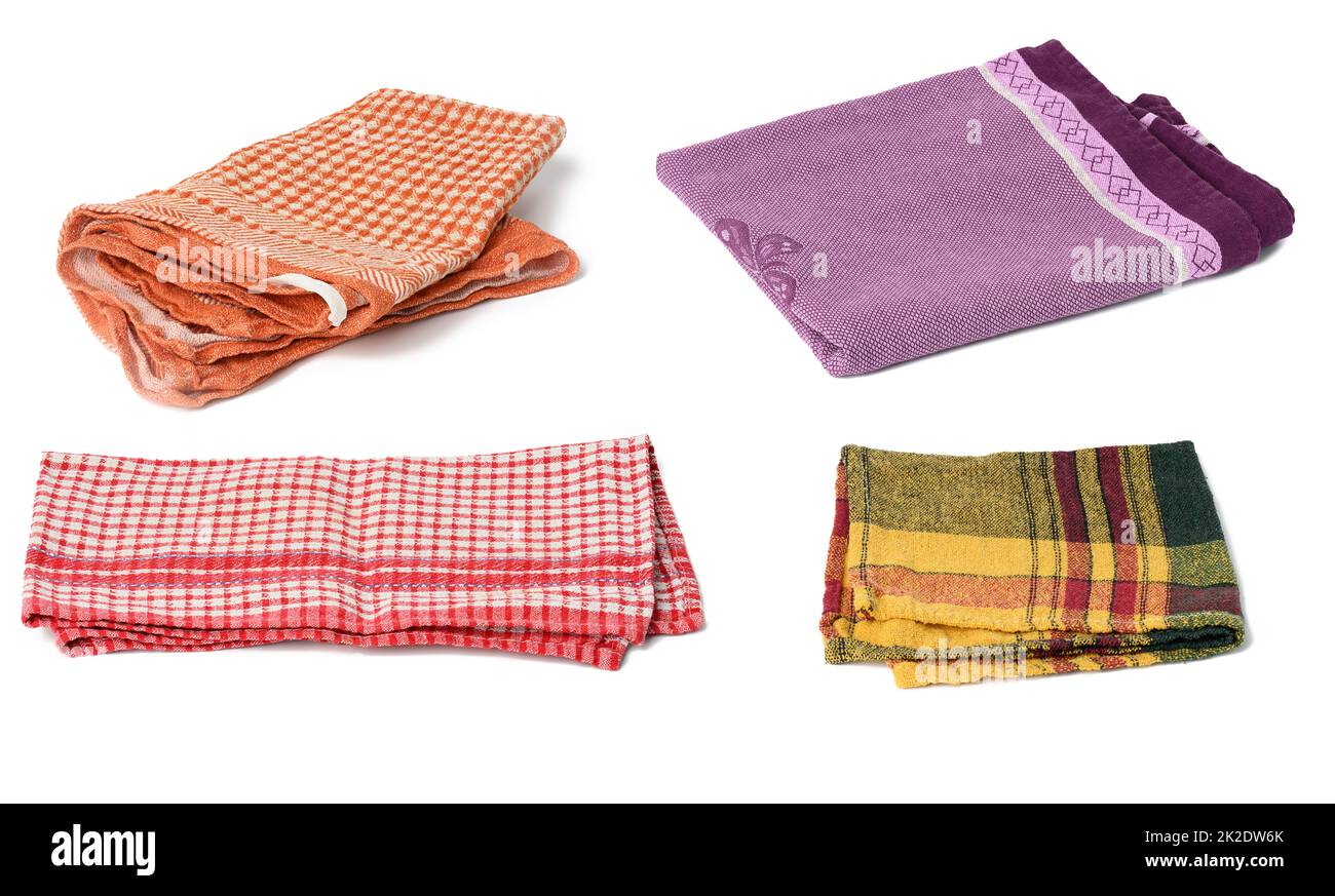 folded kitchen textile towels of different colors on a white background ...