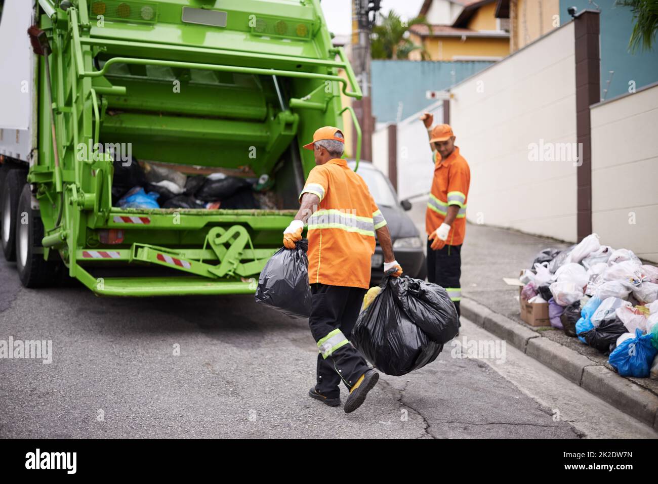 One street at a time.... Cropped shot of a garbage collection team at ...