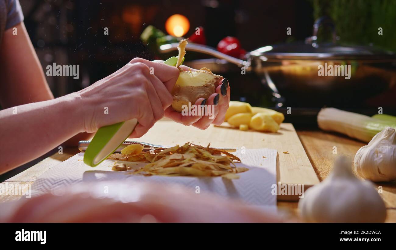 Woman peeling ginger for cooking in kitchen Stock Photo - Alamy