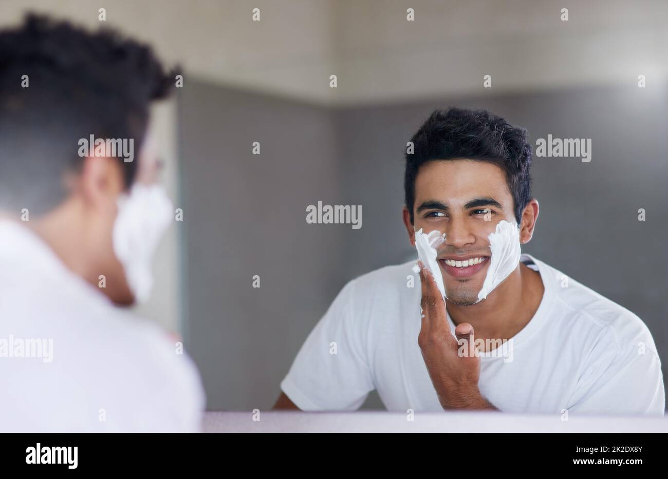 Sprucing up before a big date. Shot of a handsome young man shaving his ...