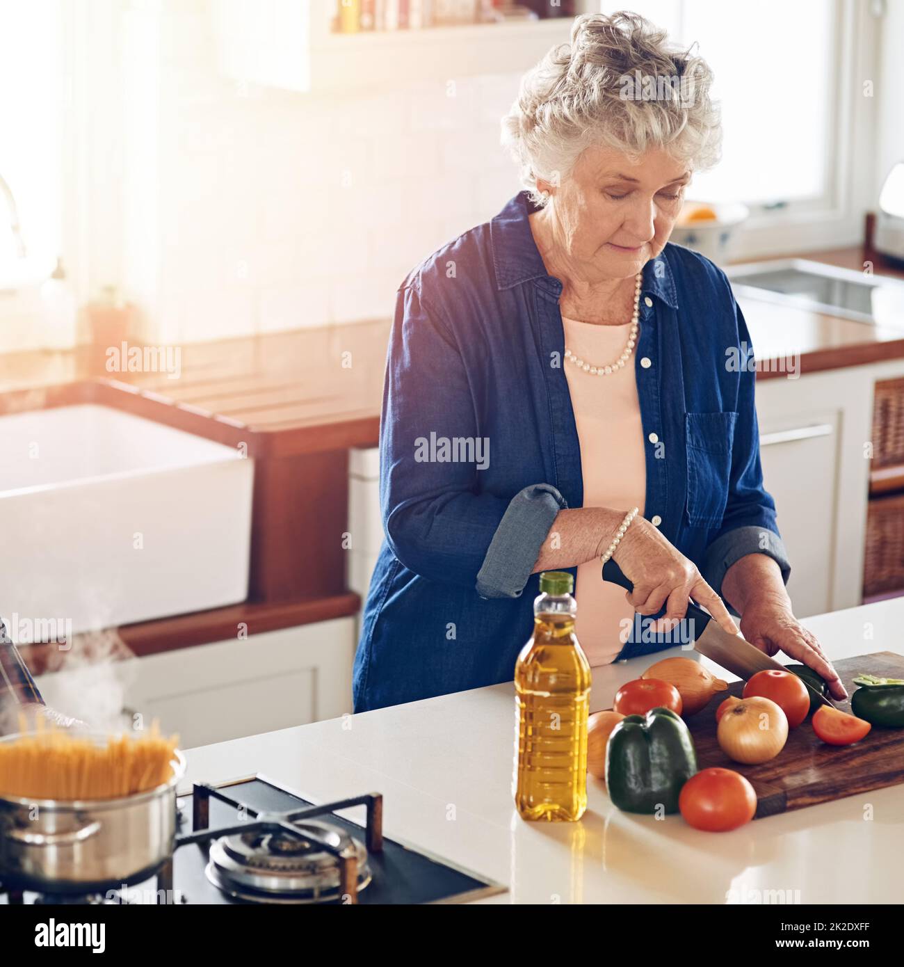 Living and eating healthy. Cropped shot of a senior woman cooking in ...