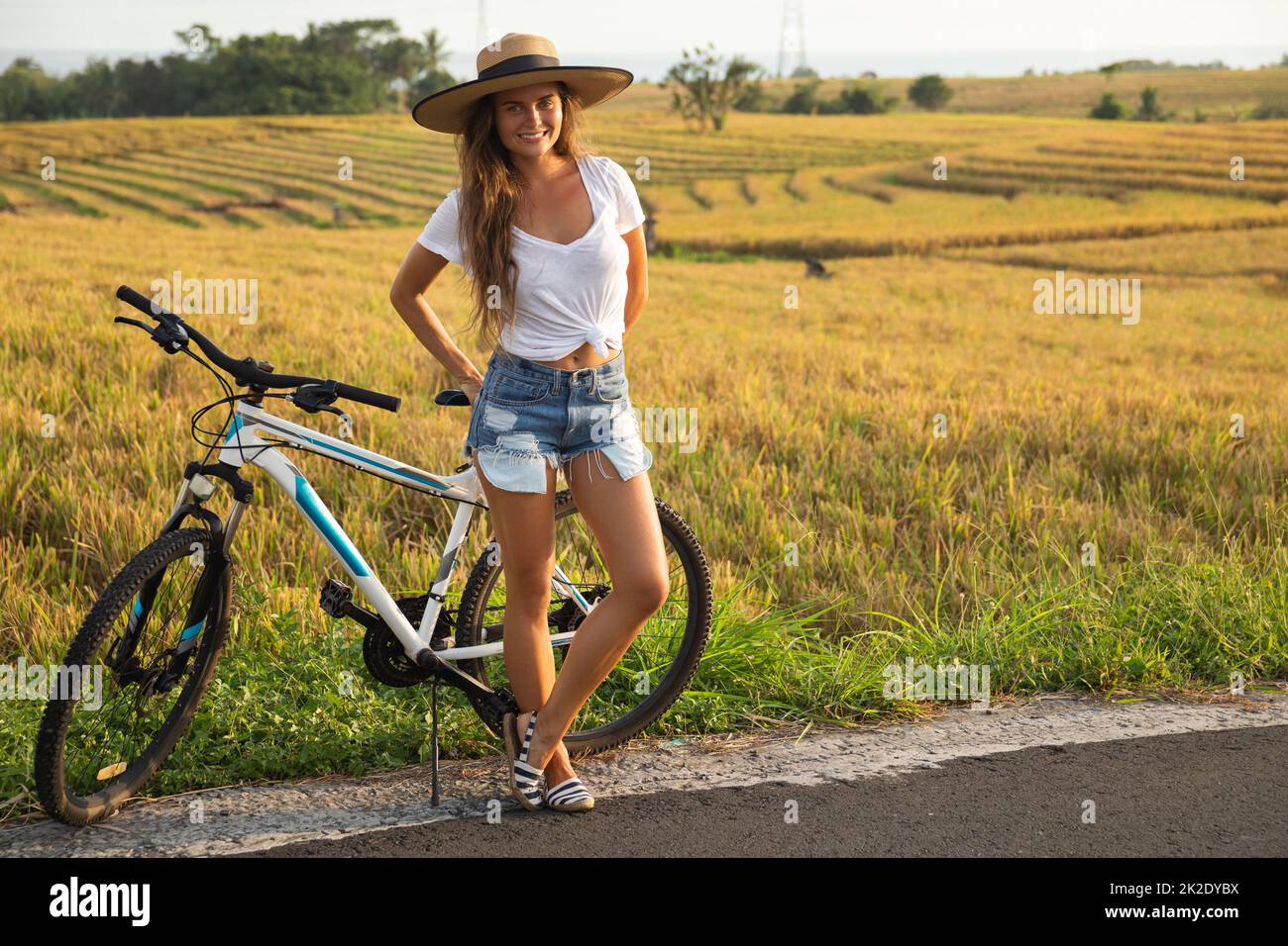 Happy woman with a bicycle on side of the road Stock Photo - Alamy