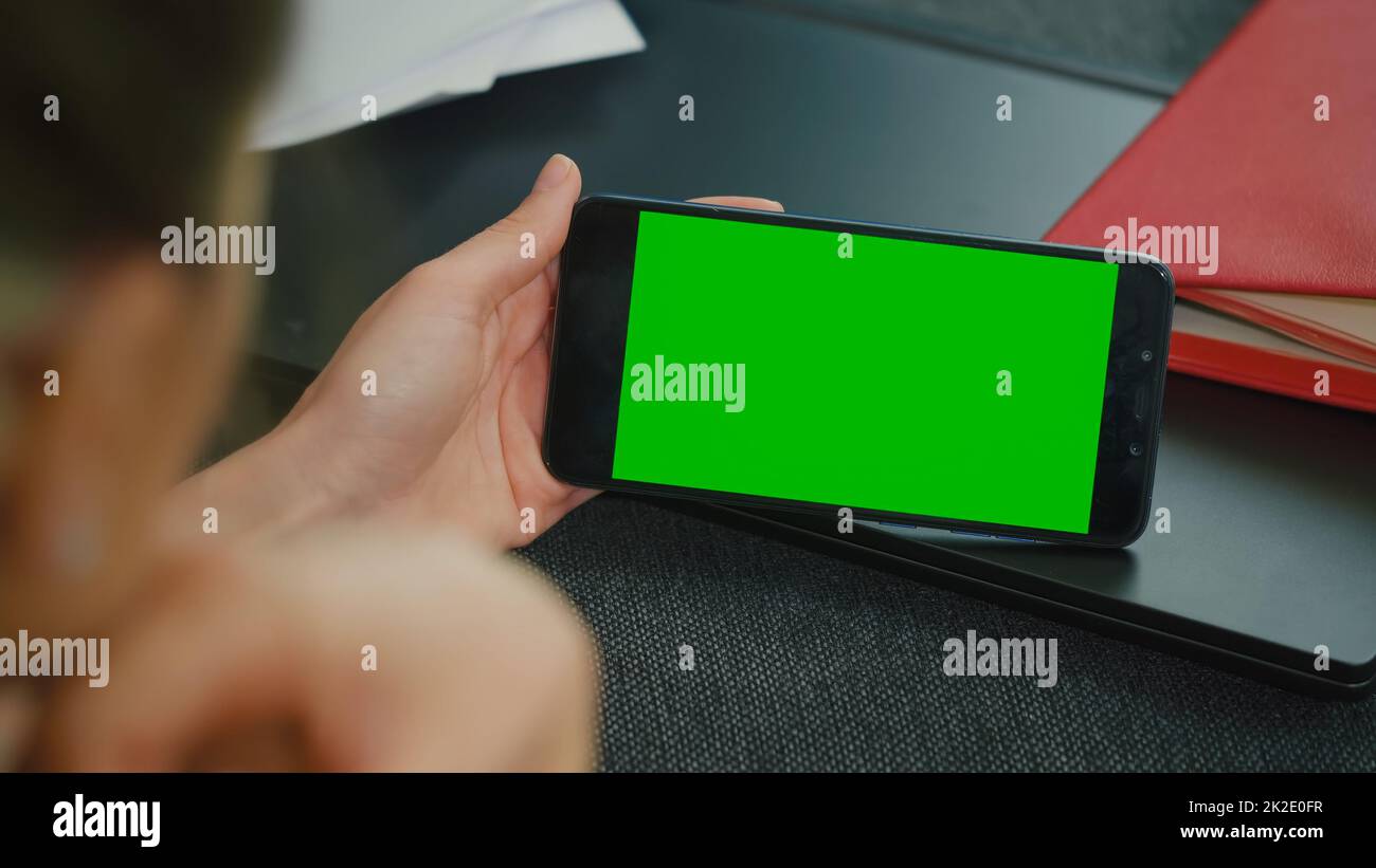 Woman sitting on a sofa with smart phone in horizontal mode . Phone ...