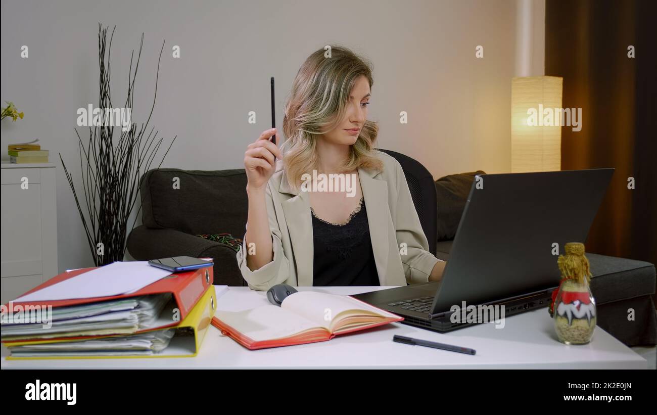 Female manager making business notes on notebook, working alone in ...