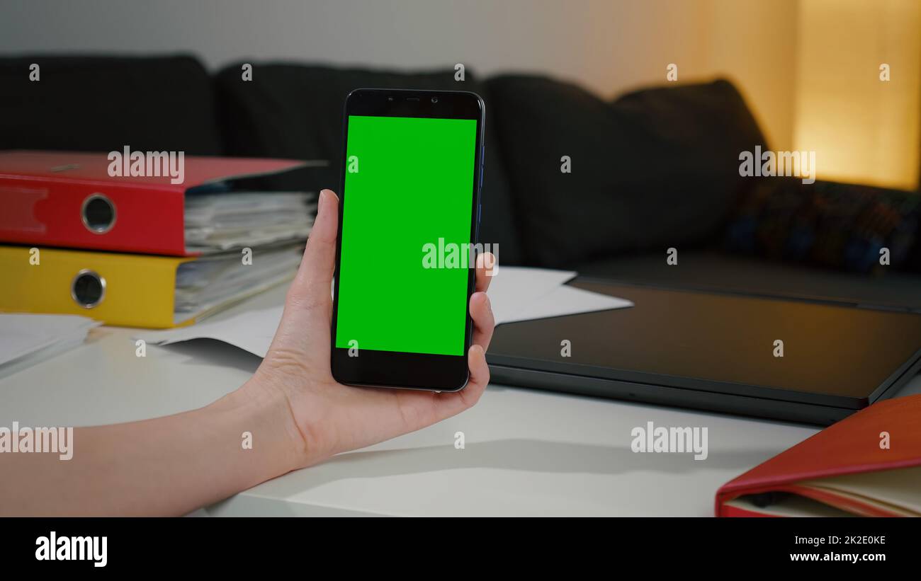 Woman at home relaxing reading on the smartphone with pre-keyed green ...