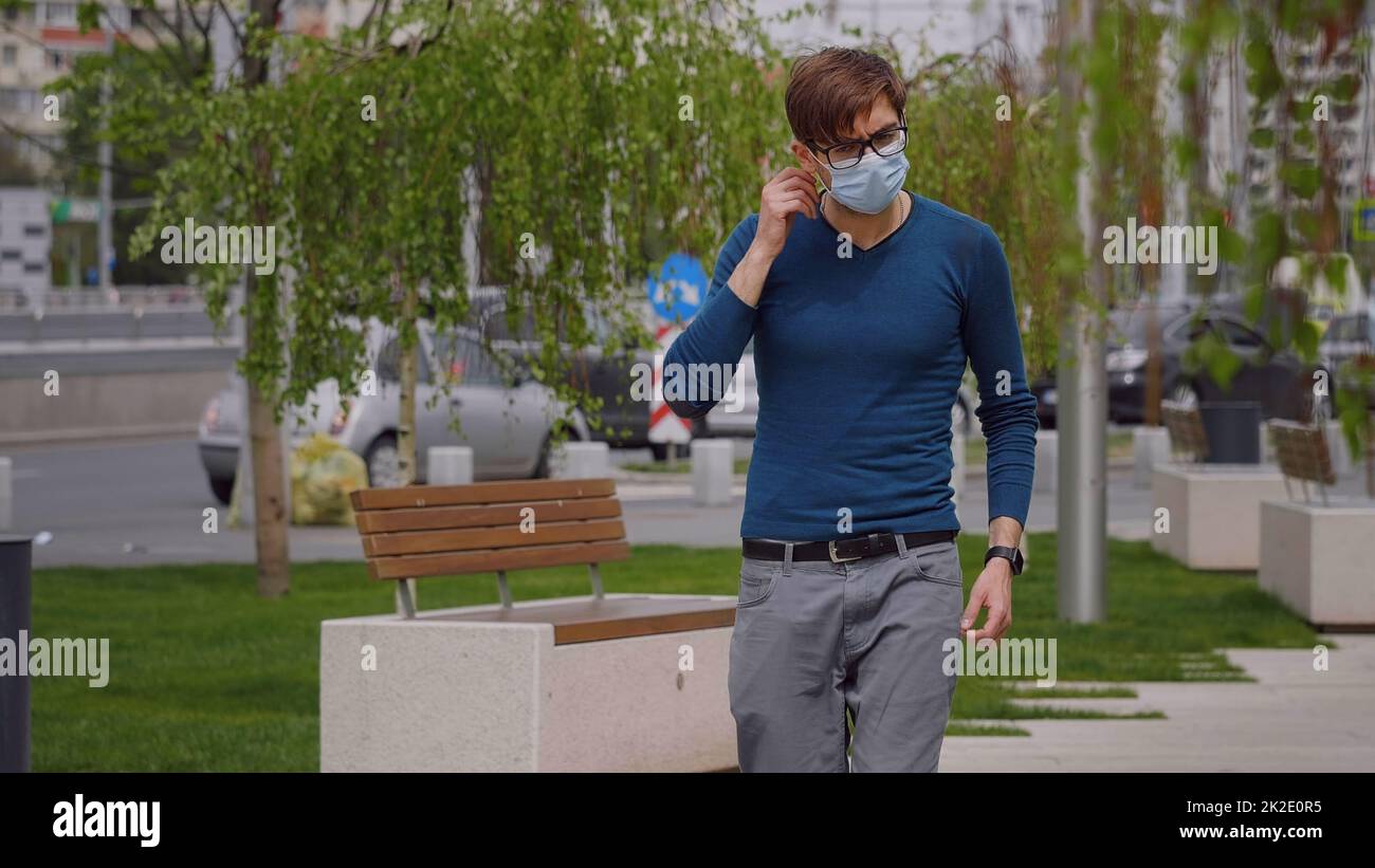 Man take off surgical mask outdoor and throws mask in the trash Stock ...