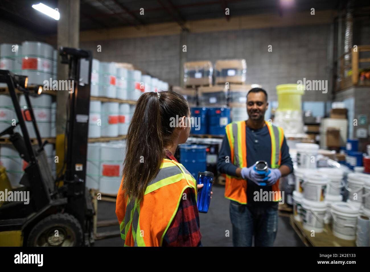 Workers in distribution warehouse talking on break Stock Photo - Alamy