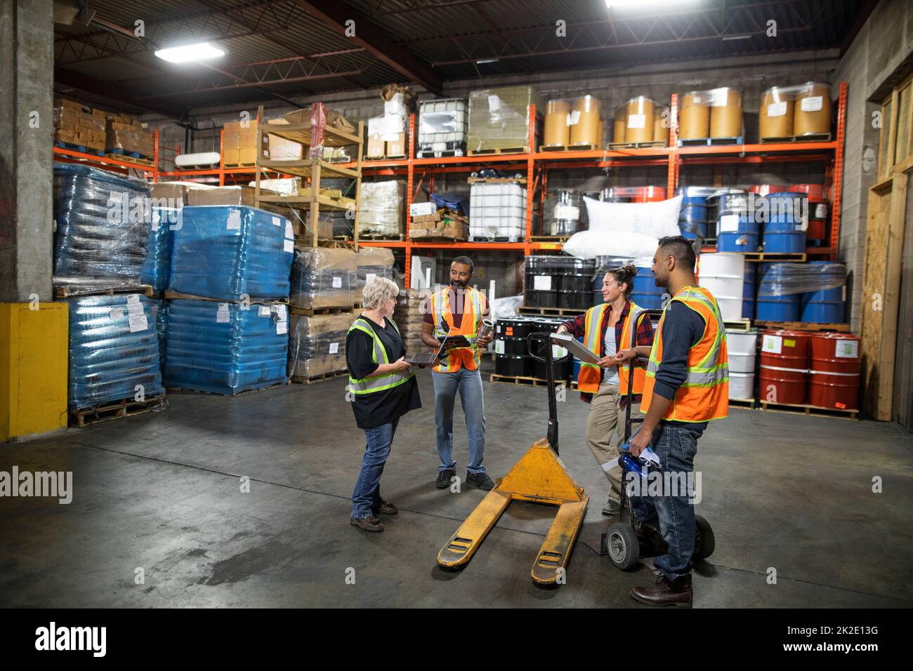 Distribution warehouse owner and workers having team meeting Stock ...