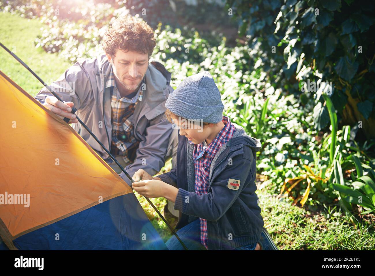 Setting up camp is part of the fun. a father and his young son putting ...
