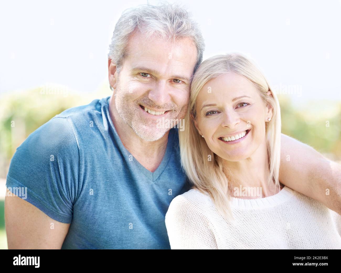 Relaxing in the park together. A happy mature couple smiling at you ...