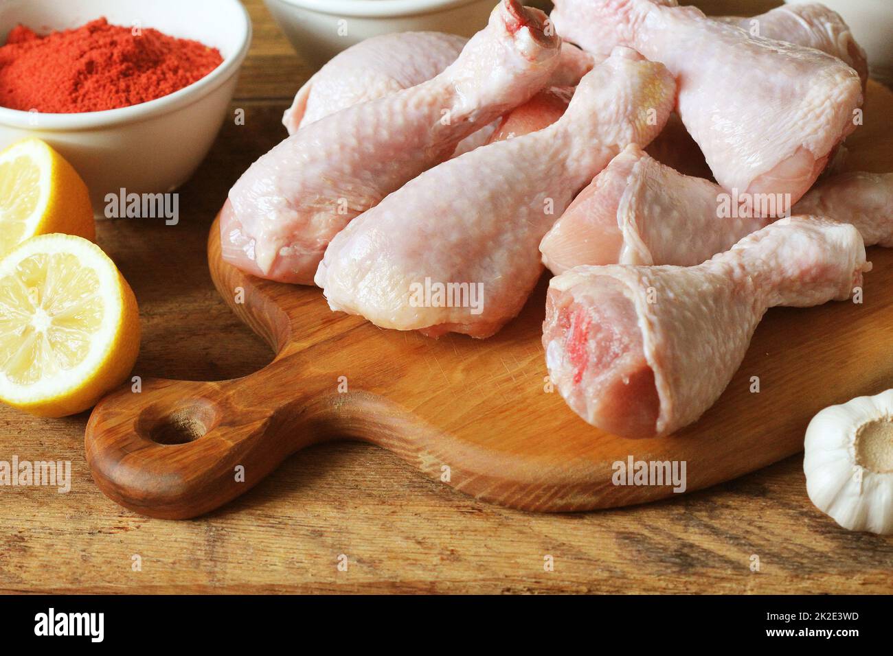 Raw uncooked chicken legs, drumsticks on cutting board, meat with ...
