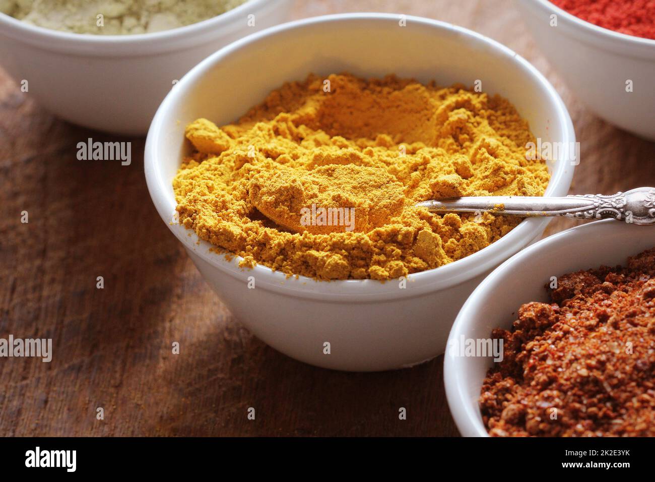 Turmeric powder.Various colorful spices on wooden table in bowls . Food ...