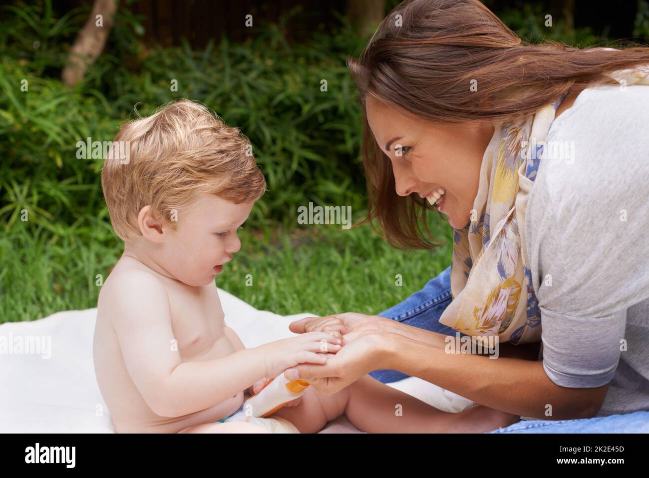 He loves the outdoors already. A young mother sitting outside with her ...