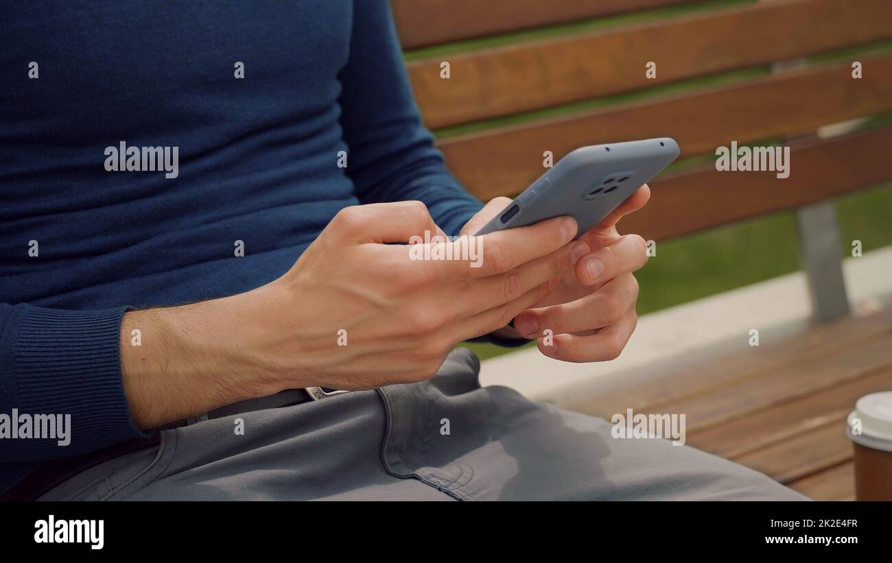 Man using mobile phone. Writing a message on smartphone outdoor park ... Man using mobile phone. Writing a message on smartphone outdoor park ...