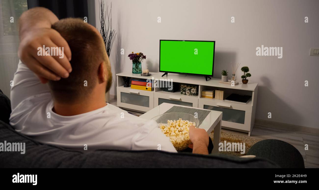 Watching Green Screen Chroma Key TV at home interior. Man Watches a ...