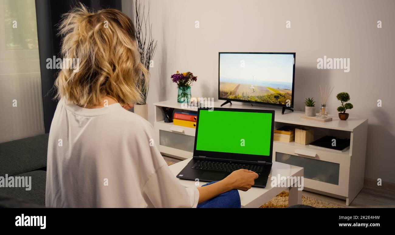 Smiling woman tell a story in a video chat with a friend. Over shoulder ...