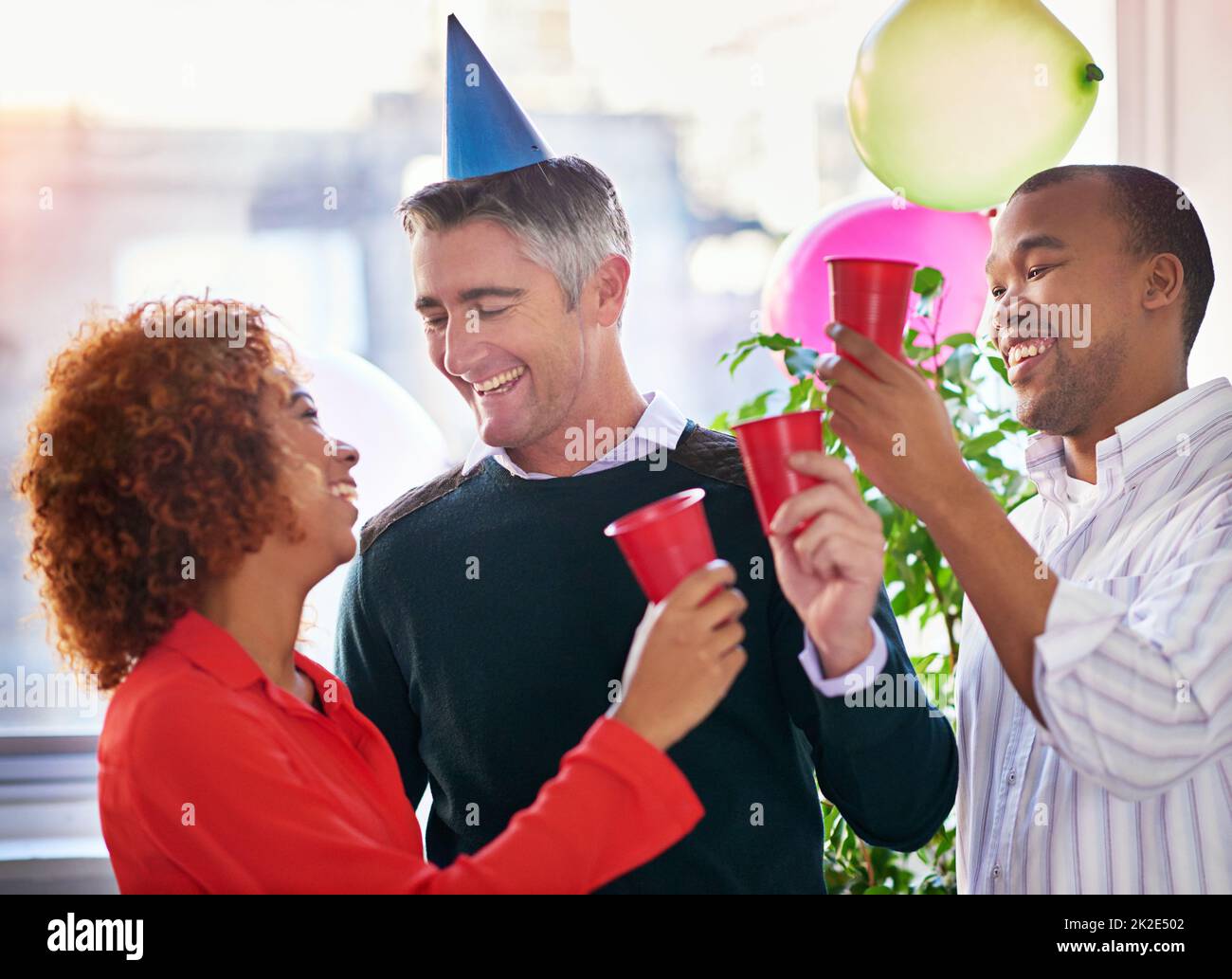 Celebrating a colleagues birthday. Cropped shot of a group of coworkers ...