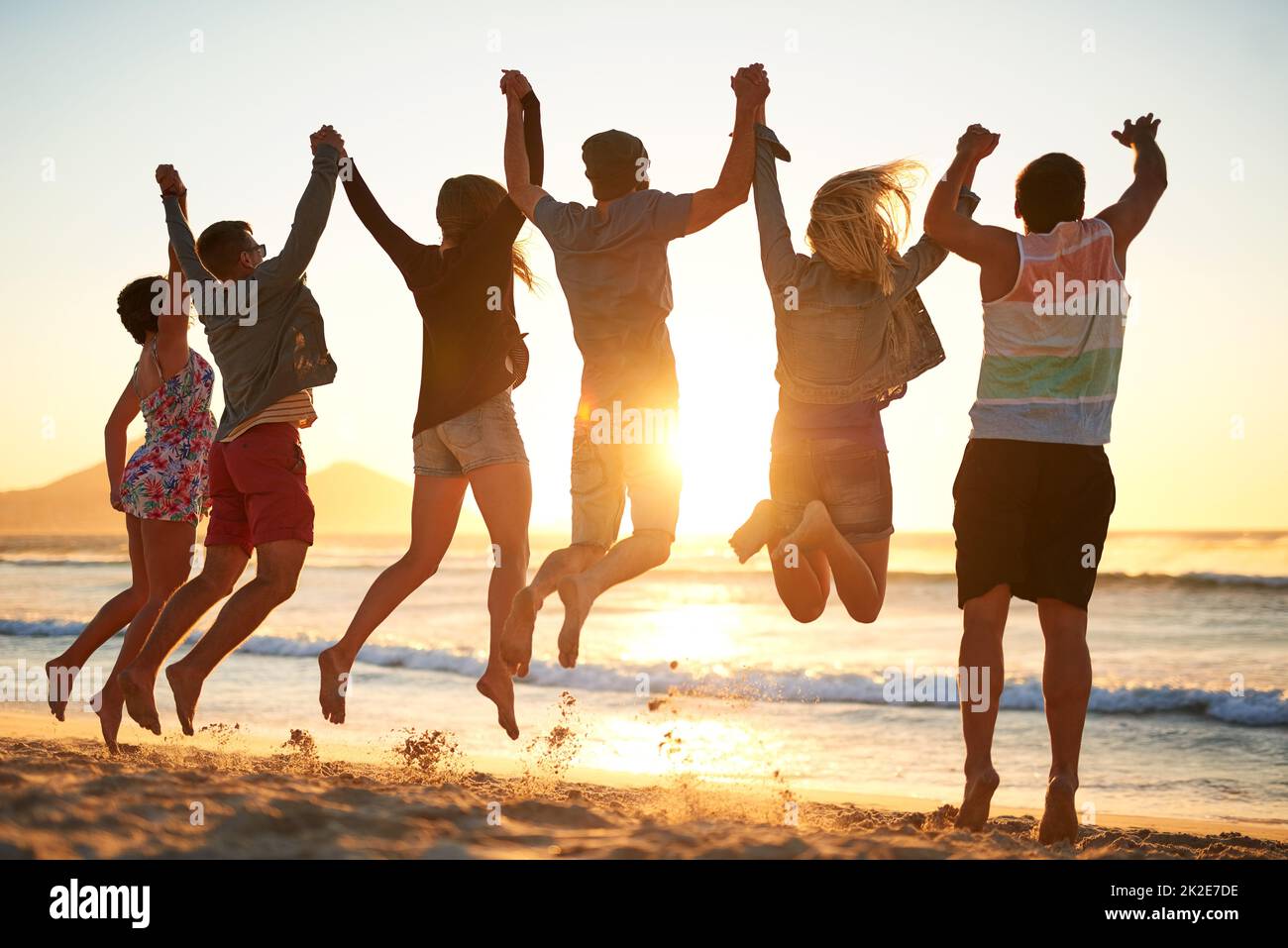Happy friends holding hands back hi-res stock photography and images ...