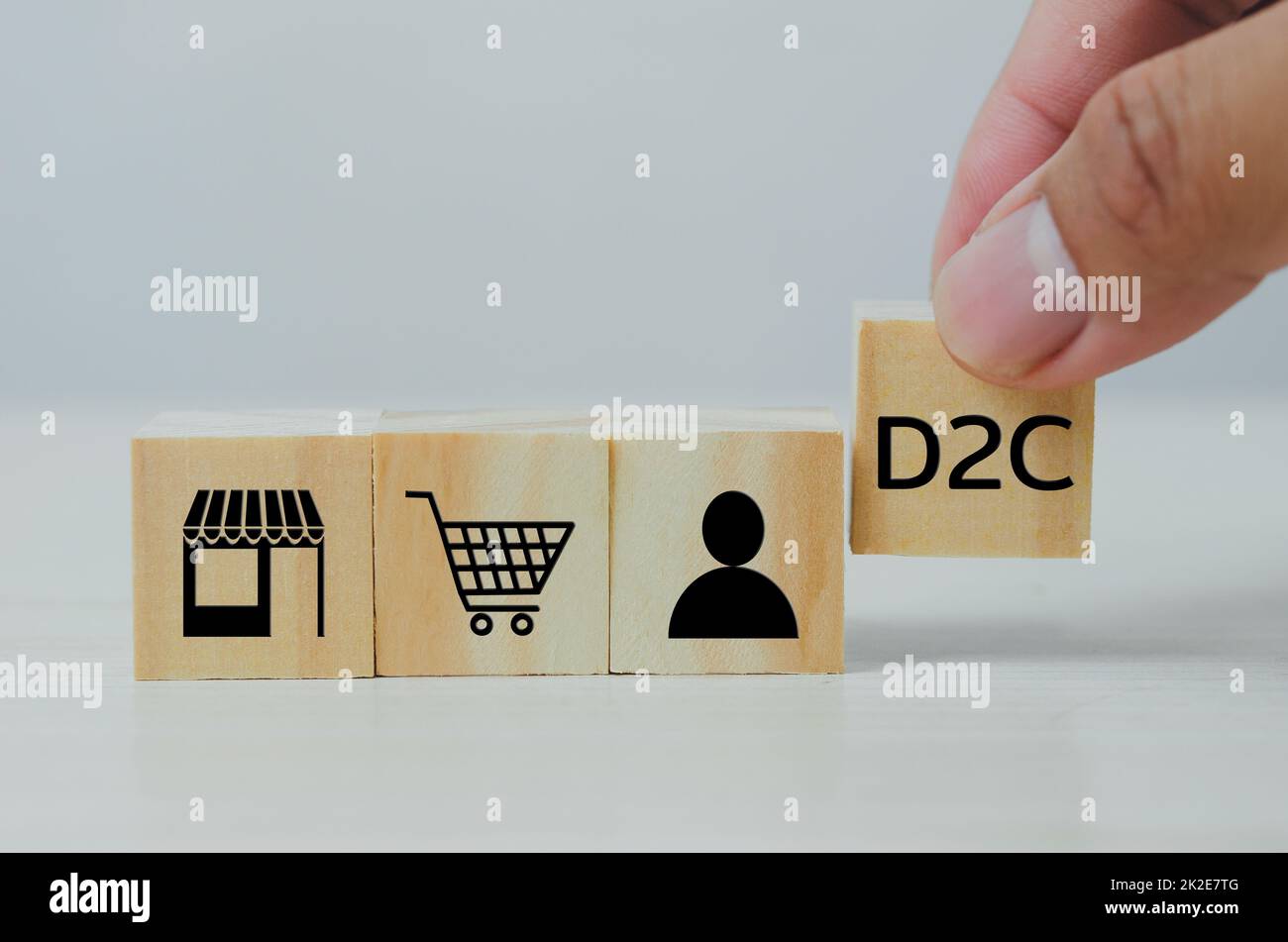 Hand put wooden cubes with Direct to Consumer D2C on table and copy ...