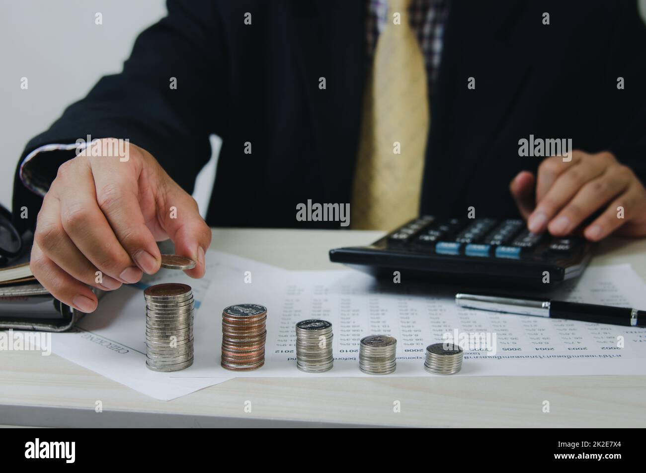 Male hands holding coins and paper documents calculator.Business ...