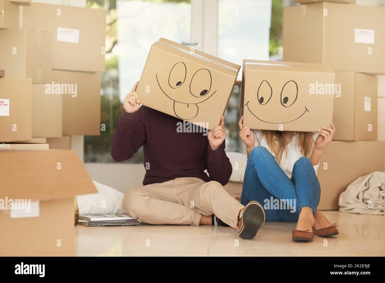 Having fun on moving day. Shot of a young couple on moving day wearing ...