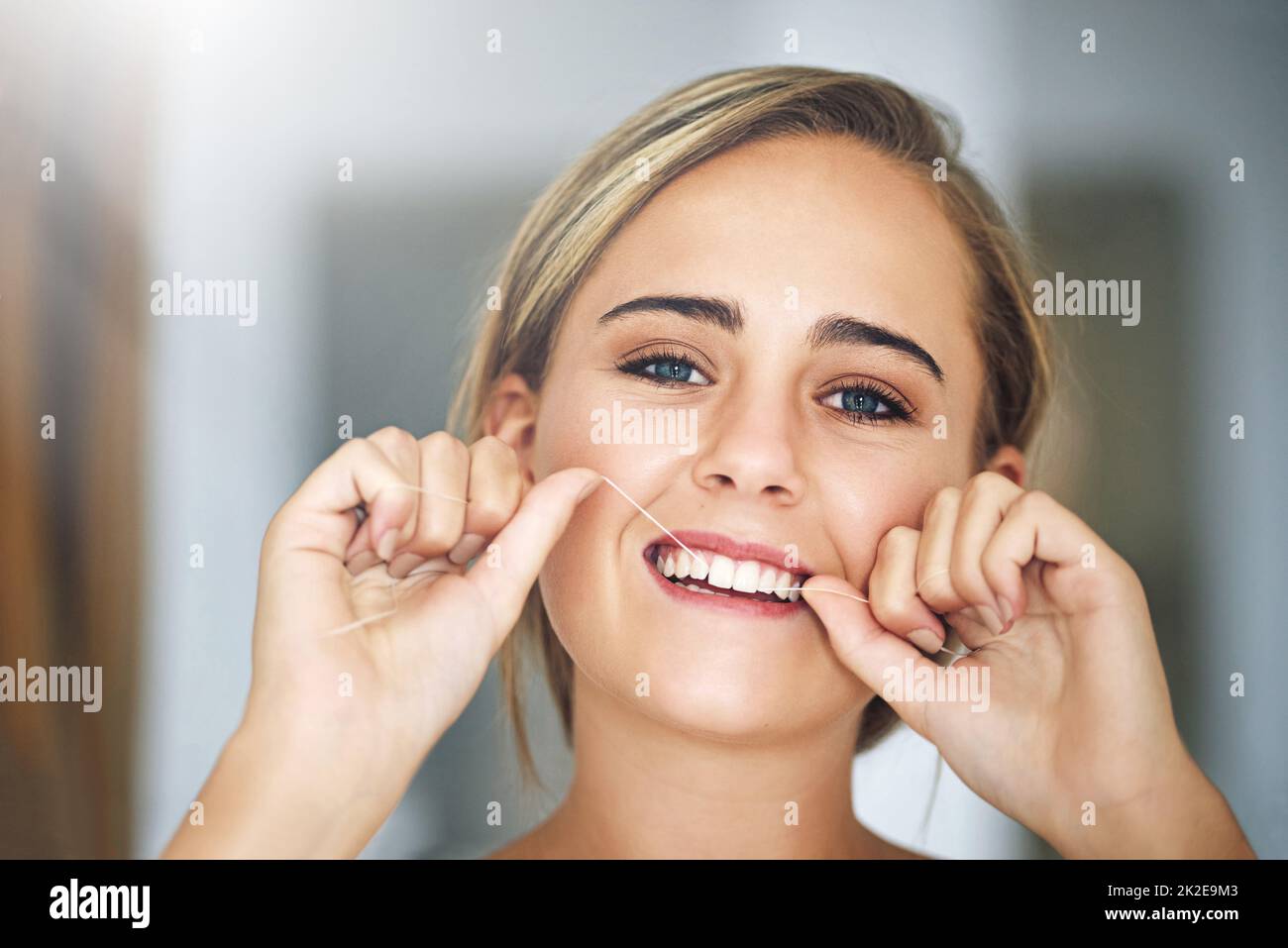 Flossing Her Way To A Beautiful Smile Portrait Of An Attractive Young