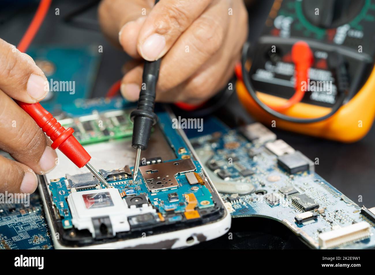 Technician repairing inside of mobile phone by soldering iron ...