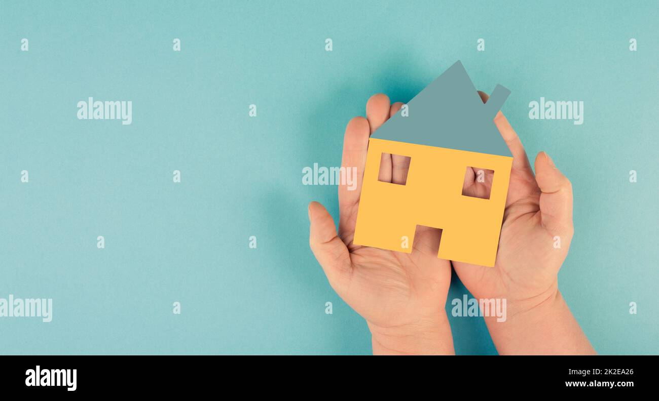 Holding a small paper house in the hands, planning to buy a new home ...