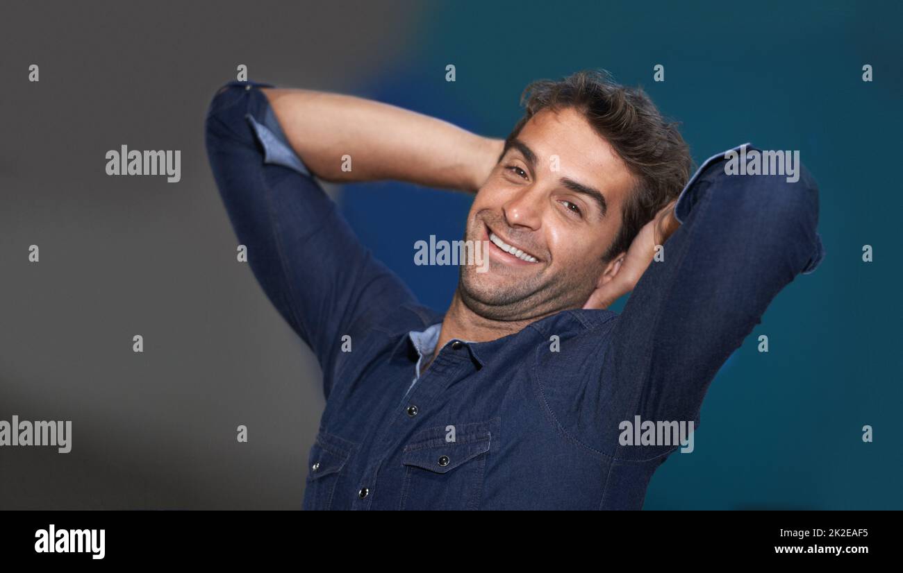 Hes just a laid back guy. A handsome young guy smiling with his hands ...