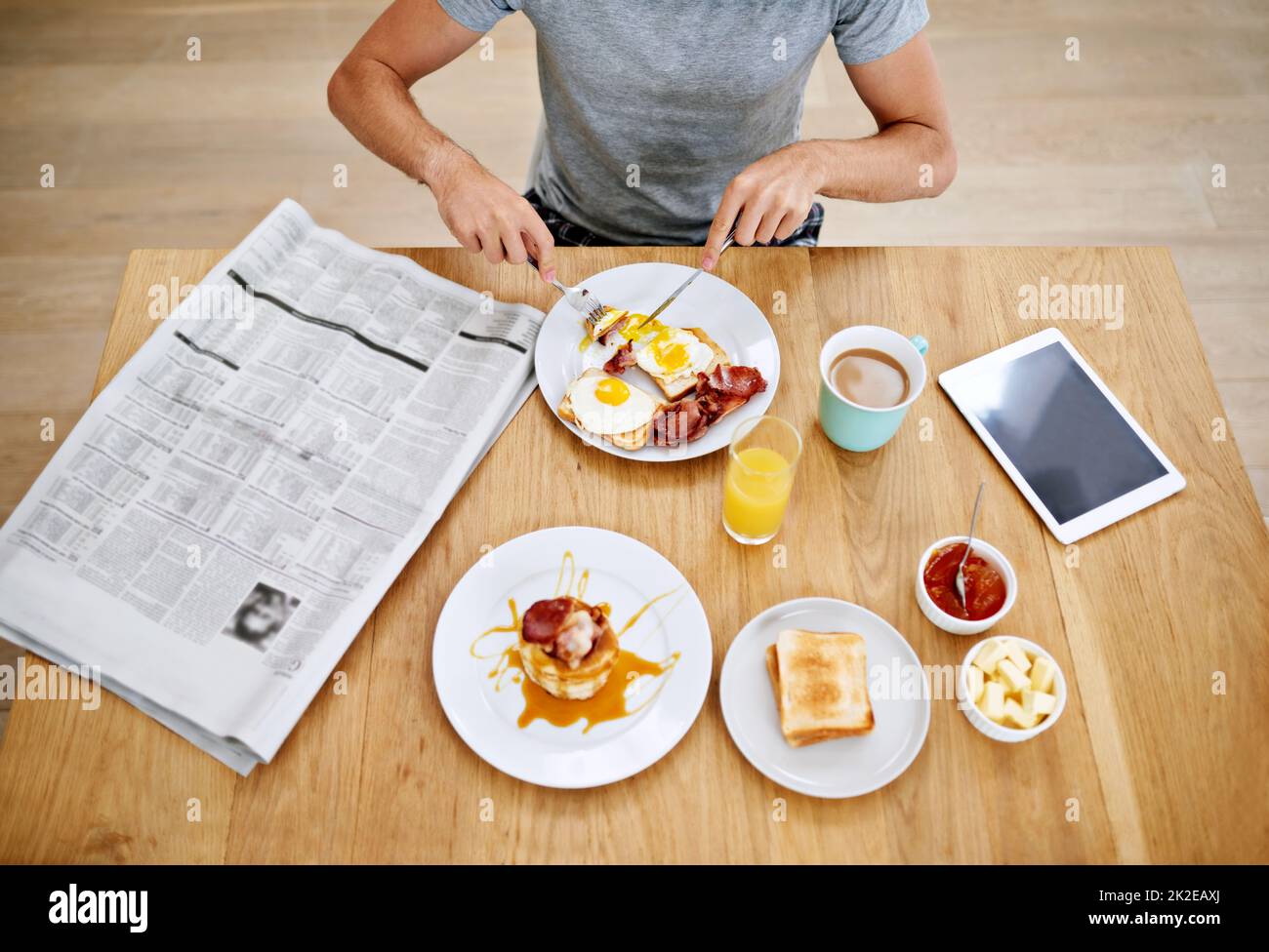 His morning routine. High angle shot of a man eating breakfast while ...