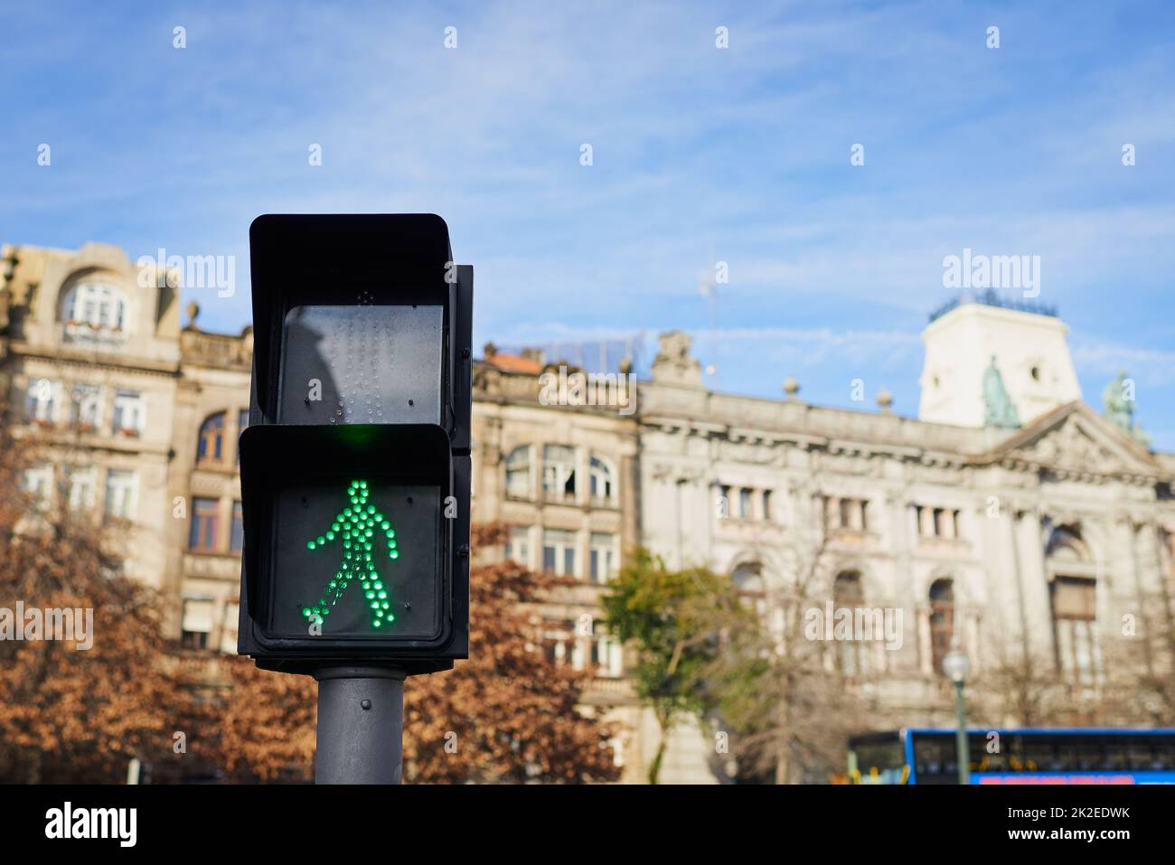 Time to go. Shot of a pedestrian traffic light with city buildings ...