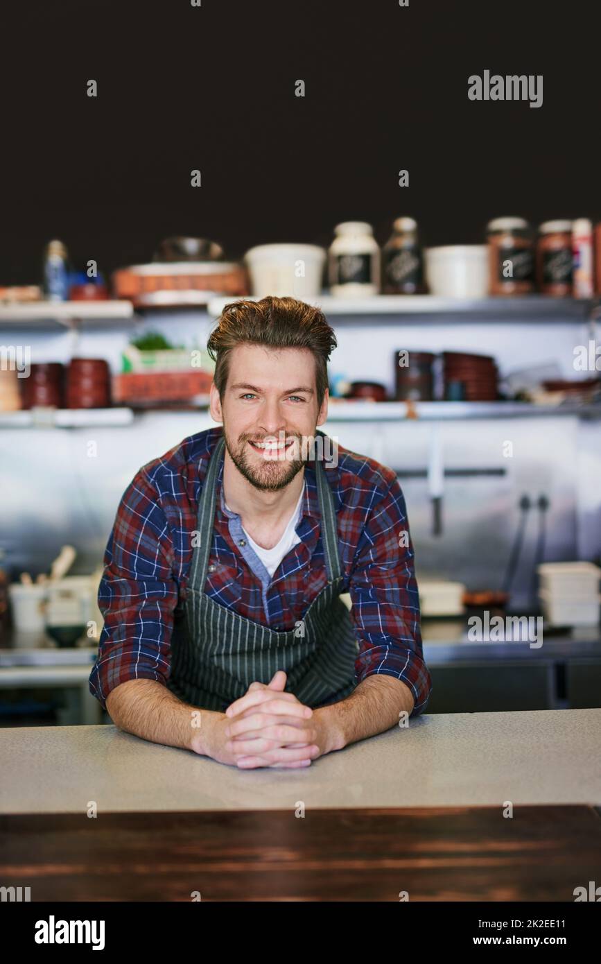 Ive got all your caffeine needs sorted. Portrait of a young barista working behind the counter ...