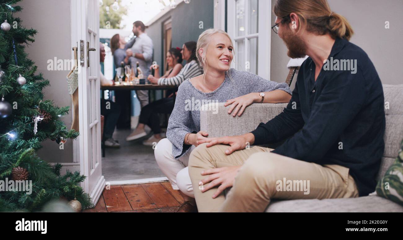 Are you enjoying the party. Shot of a young man and woman chatting at a ...