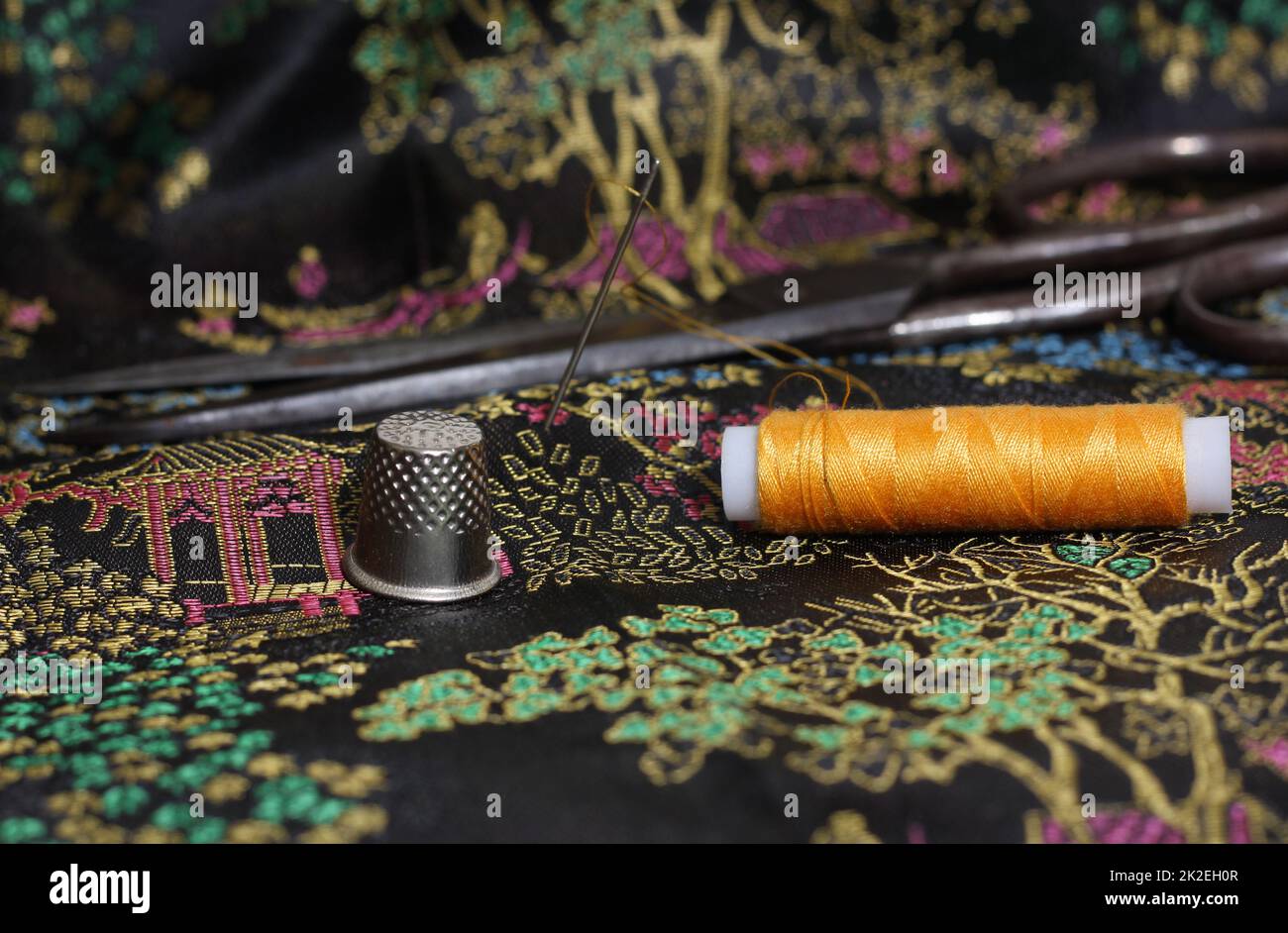 Yellow Thread and Thimble on Vintage Chinese Black Silk Stock Photo - Alamy