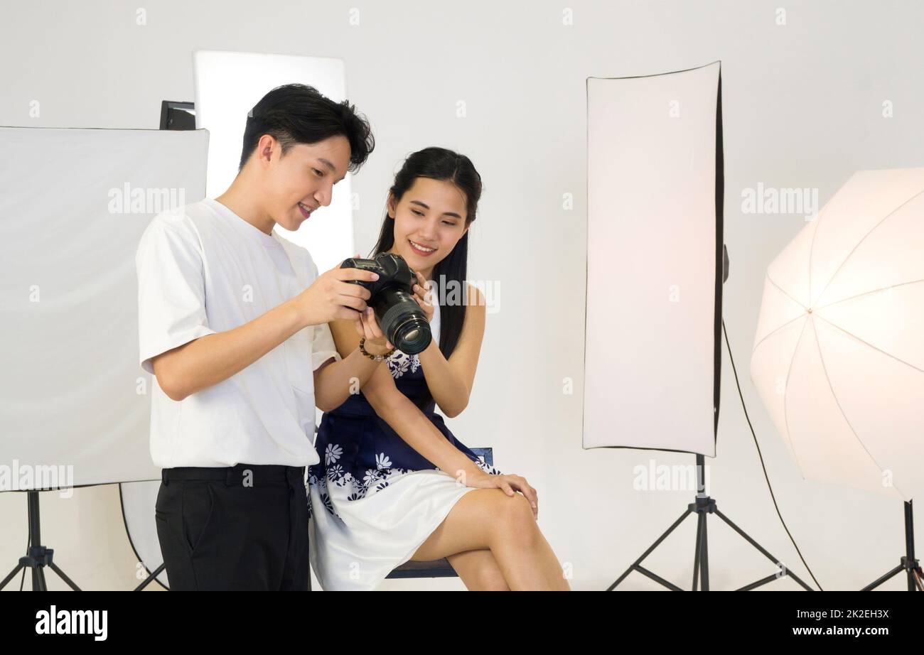 Asian photographer allow model to view picture taken on the camera ...