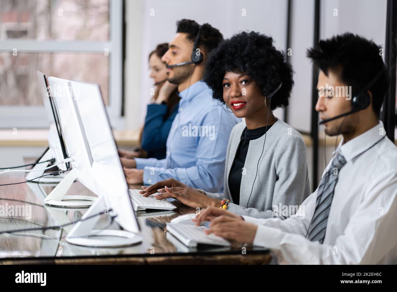Positive Customer Services Agent With Headset Working Stock Photo - Alamy