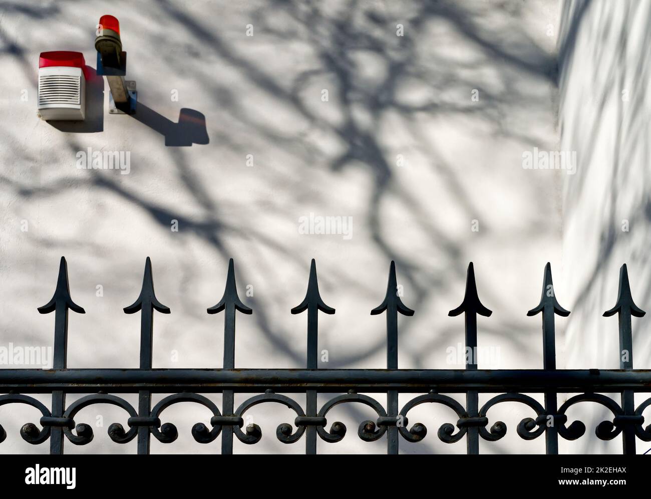 wrought-iron railing dropping shades on a wall, wall with elctric alarm ...